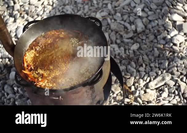 Uzbek pilaf in a cauldron boils and exudes steam on a stove Stock Video ...