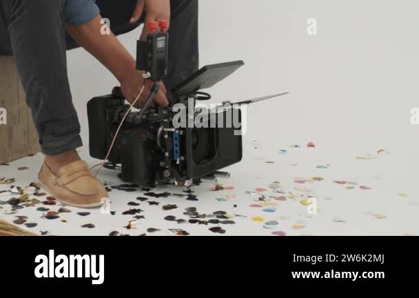 Cameraman in denim shirt shoots on red camera placed on the floor which ...