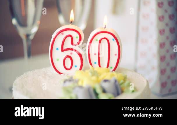 Birthday candle as number sixty 60 on top of sweet cake on the table ...