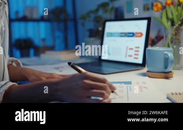 Close-up young asia lady freelance focus on laptop write worksheet ...