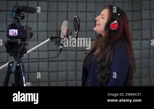 Female voice artist speaking into a microphone. Voice talent is playing ...