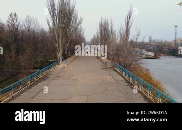 Frozen river with melting ice in winter and pedestrian bridge with ...