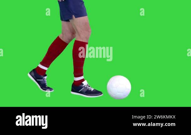 Football players feet dribbling a ball and making a pass on a Green ...