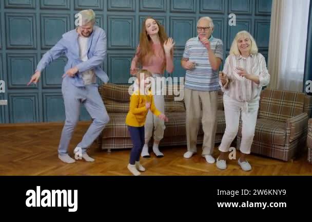 Family members of different generations having fun listening music ...