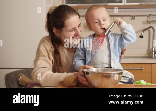 Funny little baby boy playing with cookware and flour while helping ...