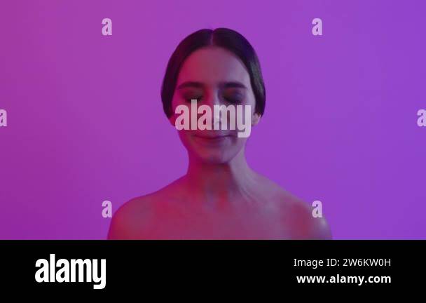 Girls face with a tear on her cheek in pink light. Pain of a young girl ...