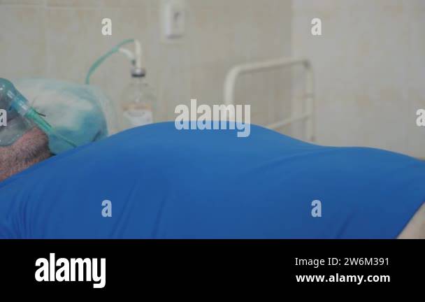 Sick man in a hospital bed. An intravenous drip is installed in the arm ...