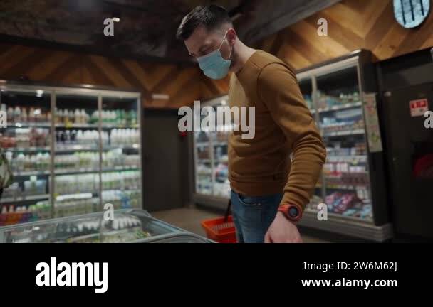 Man chooses groceries in store, walks with shopping basket, buys ...