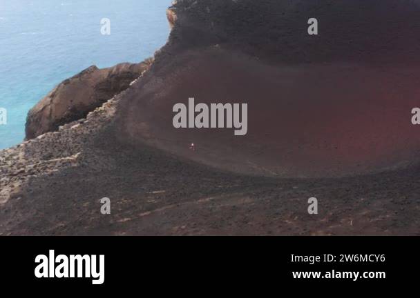 Sportsman running in crater of Capelinhos Volcano, Faial Island, Azores ...