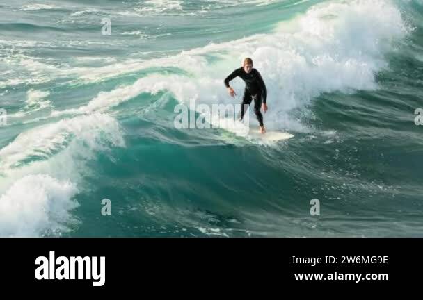 Surfer riding surfboard turning on powerful ocean wave, Slow motion RED ...