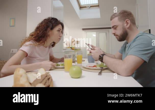 Waist-up shot of young Caucasian couple having dinner together at home ...