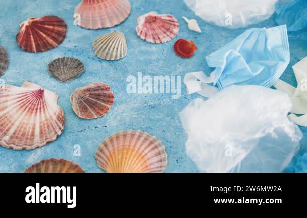 save the ocean text on blue background with sea shells and plastic ...