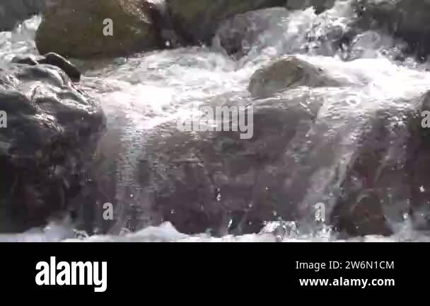 The water flowing in the fast currents hits the rocks and attracts ...