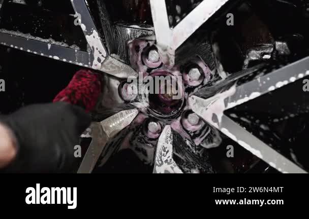 Washing the car wheel rims with neutral pH detergent that removes ...