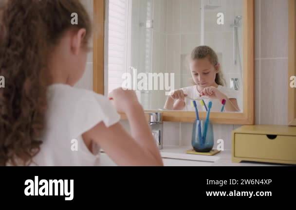 Portrait happy cute young teenage girl squeezing toothpaste onto ...