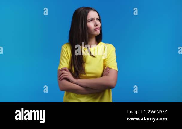Offended woman keeping arms crossed, feeling mad at someone on blue ...