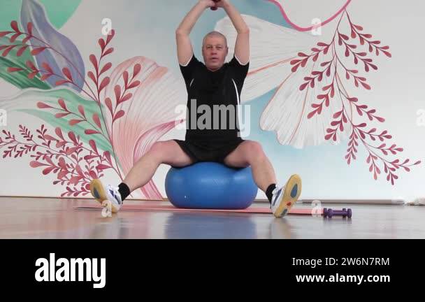 sports exercise in the gym a man trains the muscles of the arms with ...