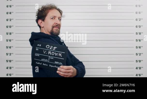 Side profile mugshot of male arrested in 40s turning head and looking ...