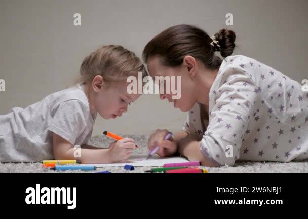 Child and Mom, nanny, teaches girl to draw. Happy family playing ...
