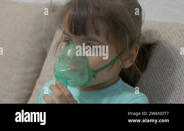 Little kid girl making inhalation with nebulizer at home. Child asthma ...
