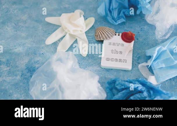 save the ocean text on blue background with sea shells and plastic ...