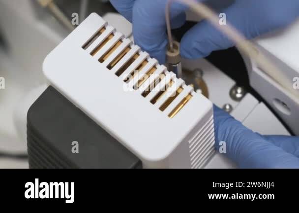 Laboratory technician unscrews the capillary into the nebulizer needle ...