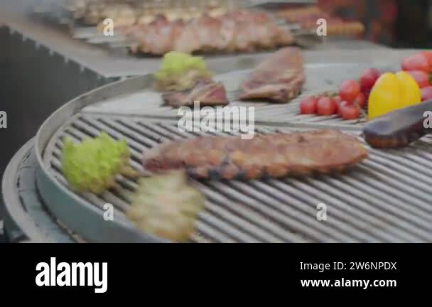 Cooking different vegetables and meats on rotating barbecue. Rotating ...