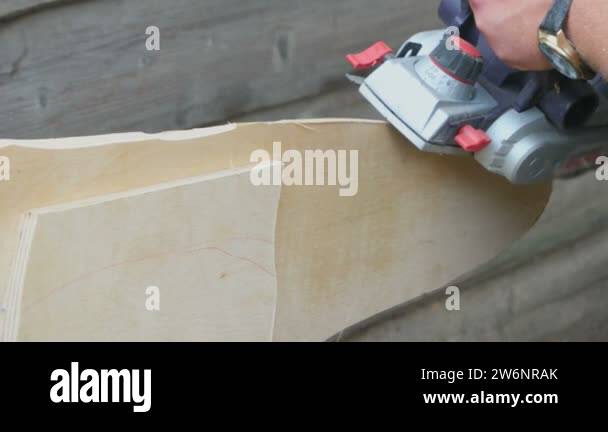 Man planing a plank of wood in his carpentry workshop with a plane to ...