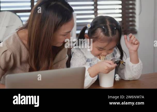 Asian family young mother and her little daughter smiling using laptop ...
