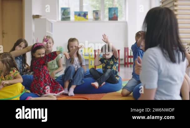 Storytime elementary or primary school teacher reading a story to a ...