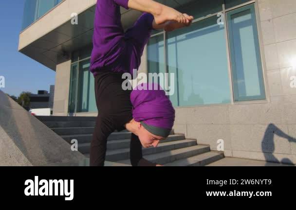 Pincha Mayurasana balance outdoors. Moving footage muslim girl wearing ...