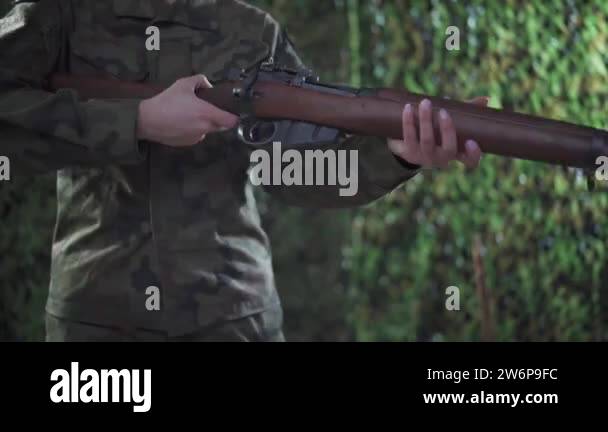 The lady soldier raises her self-reloading rifle and reloads the weapon ...