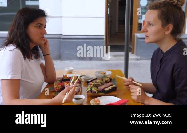Two girlfriends chatting during their lunch at Japanese restaurant ...