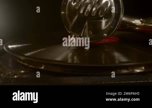 Mans hand starts mechanism of a gramophone playing music from a vinyl ...