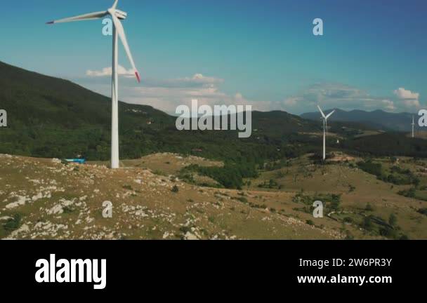 Aerial footage of a drone rotating over spinning wind turbines highly ...