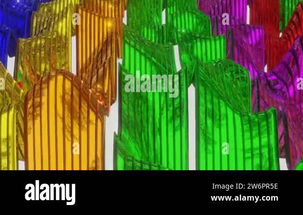 rotating multi-colored spheres on cylinders slowly rise and fall into ...