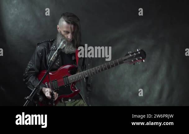 Rockstar with shaved temples, beard and leather jacket stop plays and ...