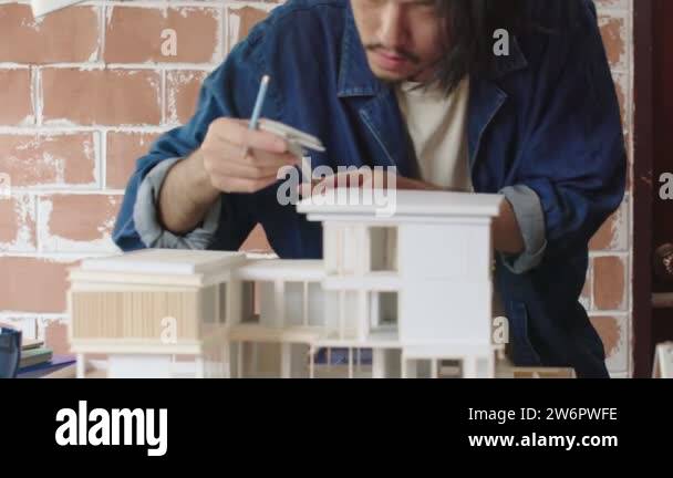 Smart asian male Architect working with his architectural model ...