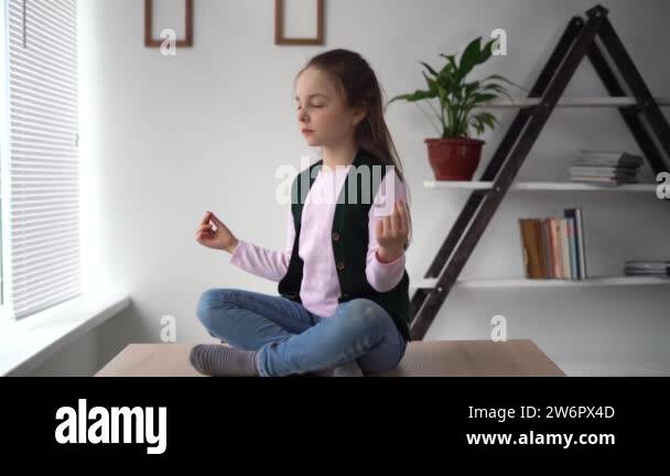 Meditation and relaxation of a little teen sitting on a desk in a lotus ...