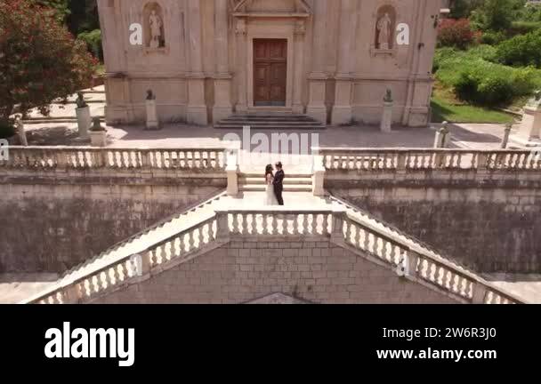 The bride and groom stand hugging on the ancient stairs of the Nativity ...