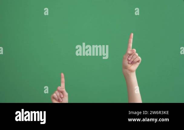 Kid hands raising up and fingers pointing up over empty chroma key ...