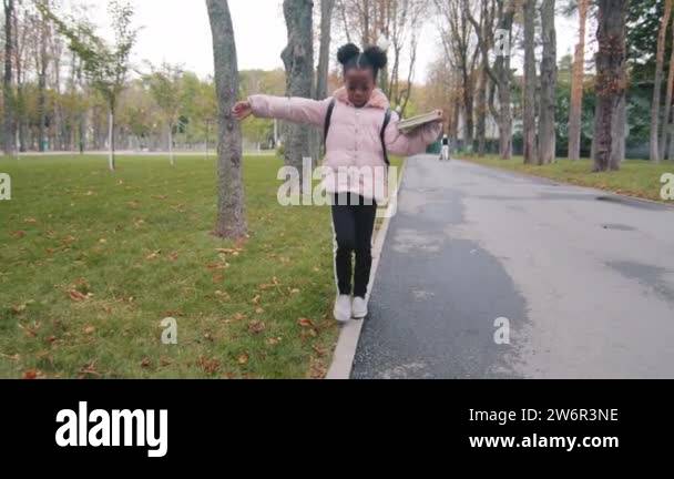 African american little girl walking on curb border balancing way from ...