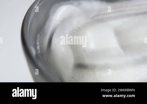 Stirring and whipping milk with a mixer in a gray bowl in slow motion ...