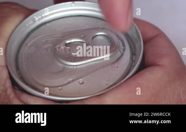Closeup hands are opening aluminum can of coffee with a gas inside ...