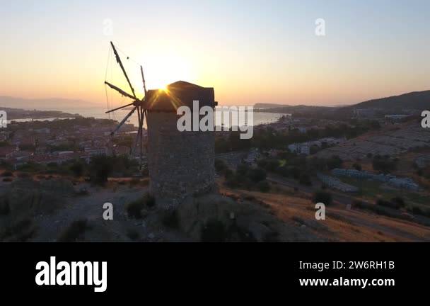Old traditional historic windmill by the sea at the sunset.Wind power ...