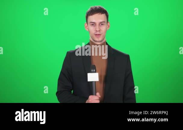 Man reporter in suit looks into the camera and speaks into a microphone ...