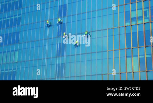 Five men workers in red and yellow work clothes cleaning the exterior ...