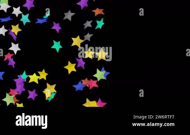 Many colorful stars floating in air on black background. Star icons ...