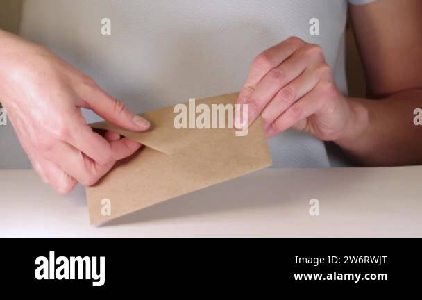 Female hands open a brown paper envelope and take out a letter, full hd ...