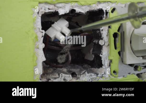 Finding defects in a broken old dangerous wall outlet with dusty wires ...